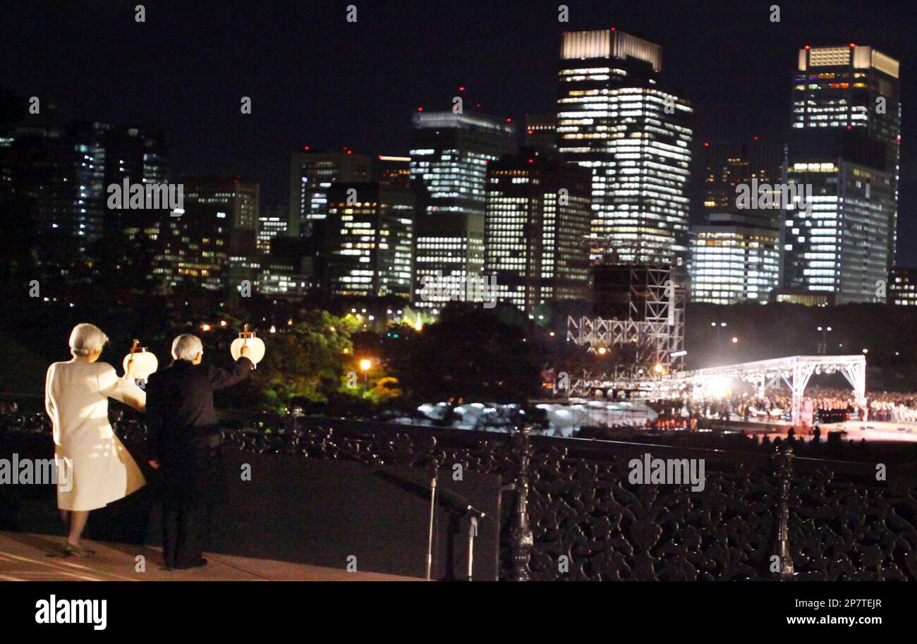 Japanese Emperor Akihito, right, and Empress Michiko wave paper ...