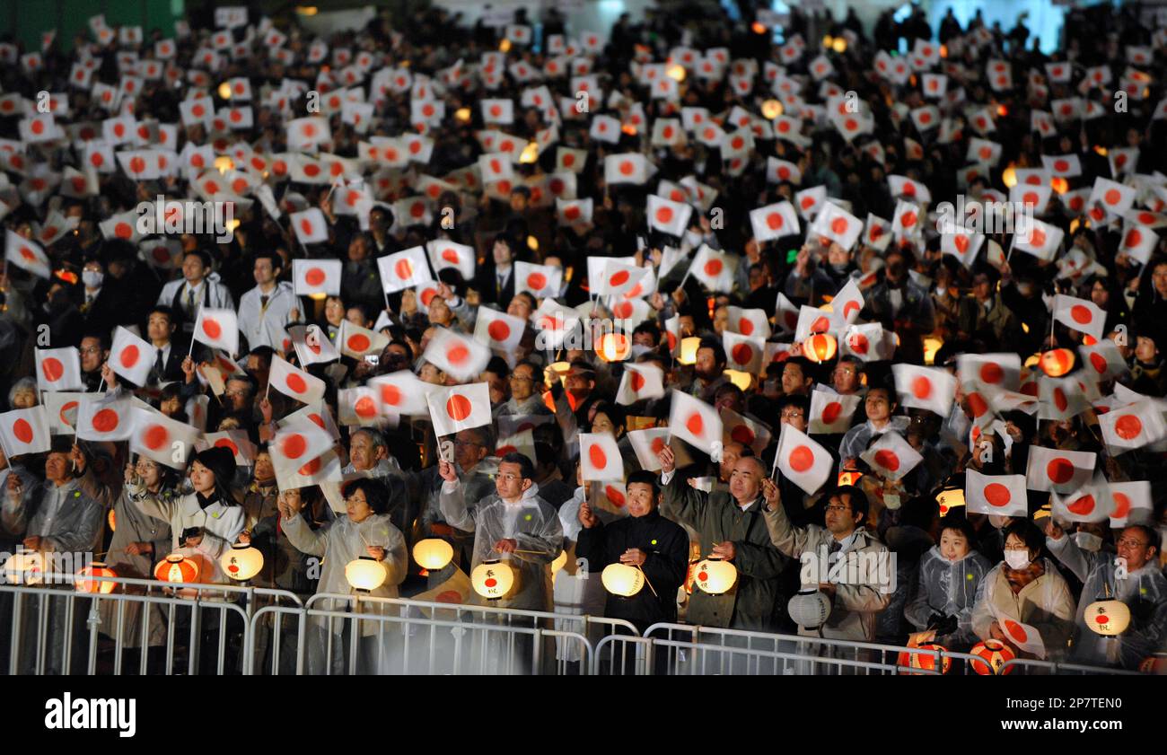 Well-wishers wave national flags as Emperor Akihito and Empress Michiko ...