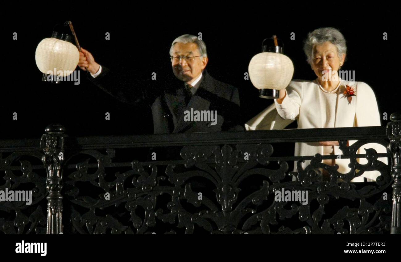 Emperor Akihito, left, and Empress Michiko wave paper lanterns as they ...