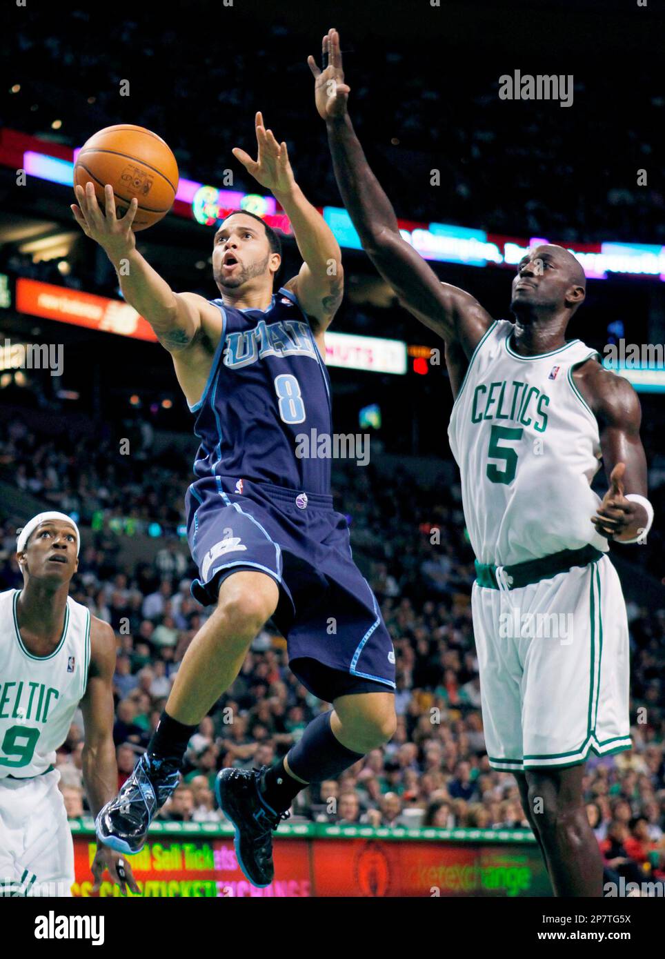 Utah Jazz's Deron Williams (8) goes up to shoot between Boston Celtics ...