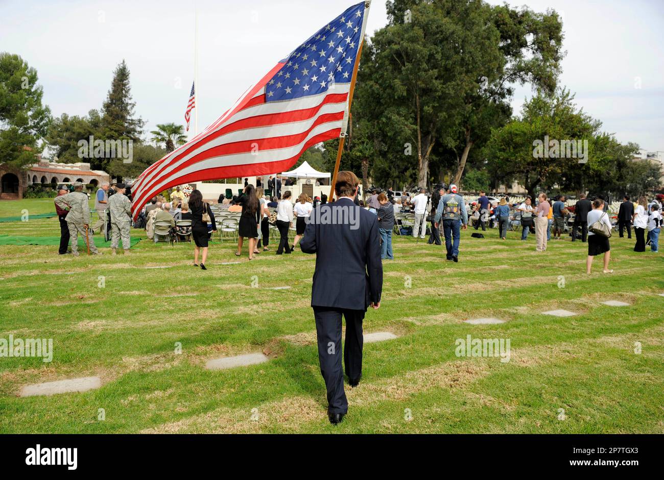 Roger Hall of Los Angeles carries an American flag to a Veteran's Day ...