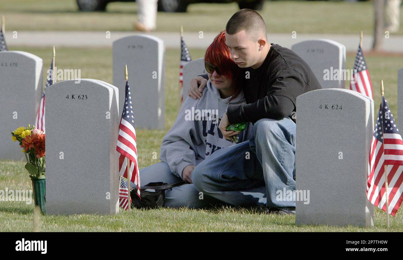 Derek Ryder and his sister Danielle Ryder sit by the gravesite of their ...