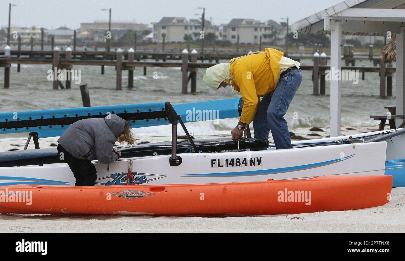 Alex Cooke, right, and his daughter Isabella Cooke, work to tie down ...