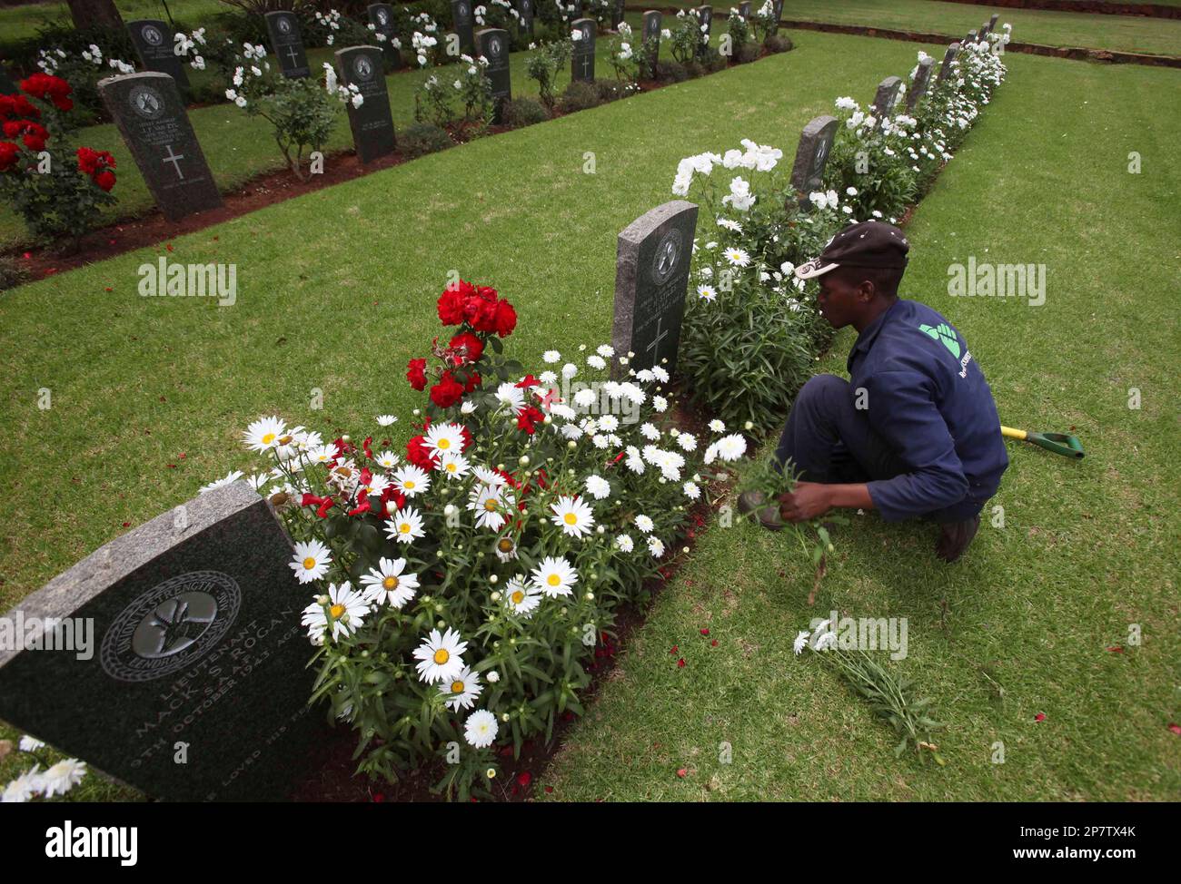 This Oct. 28, 2009 photo shows a gardener tending flower beds in a ...