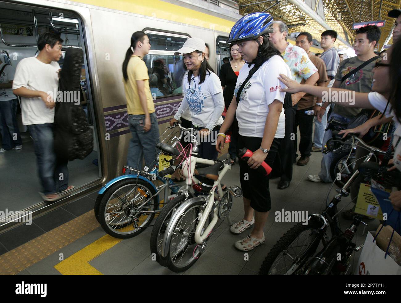 Filipino women with folding bikes prepare to ride the Light Rail ...