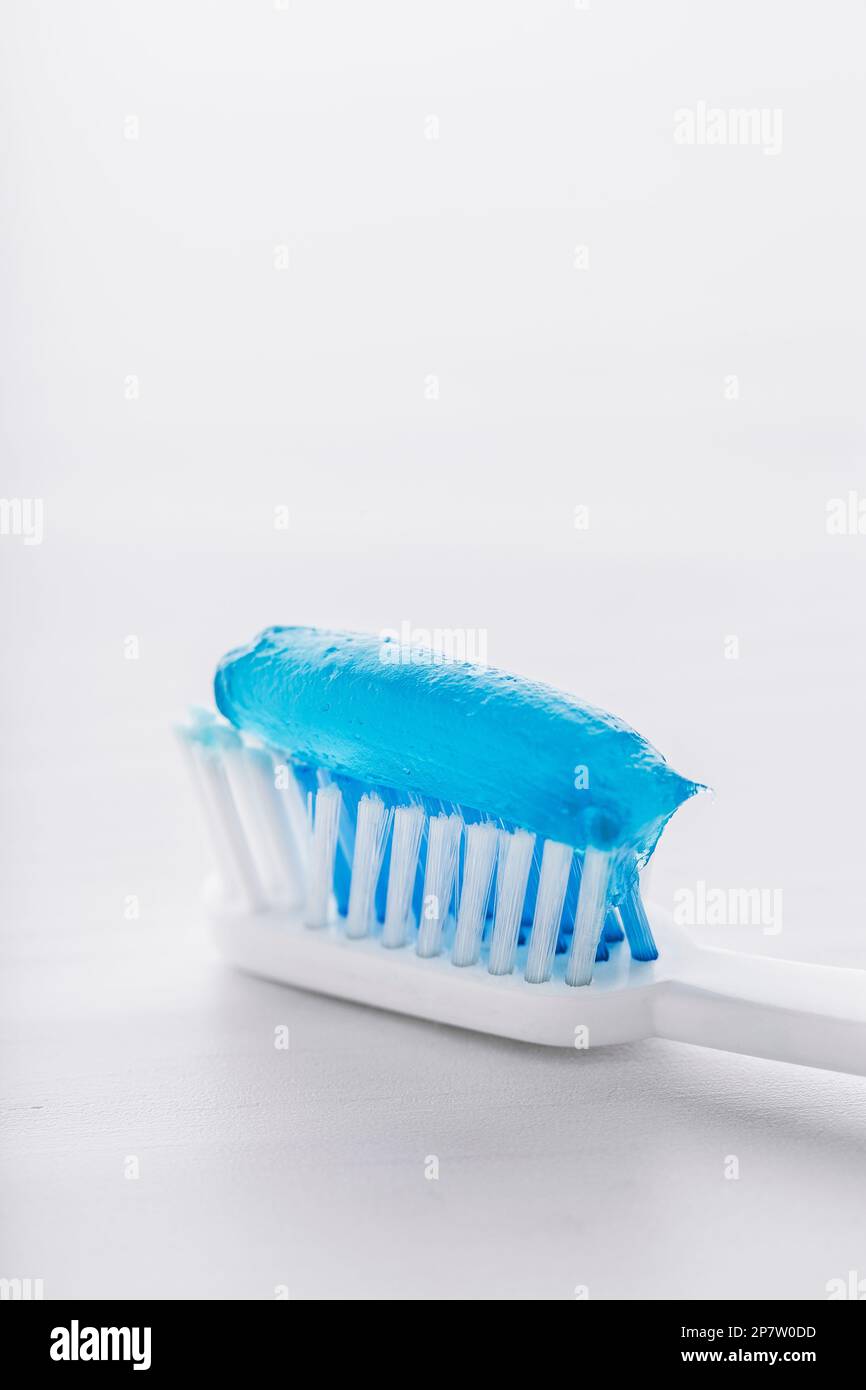 Blue toothpaste on a toothbrush for daily dental cleaning. Still life ...