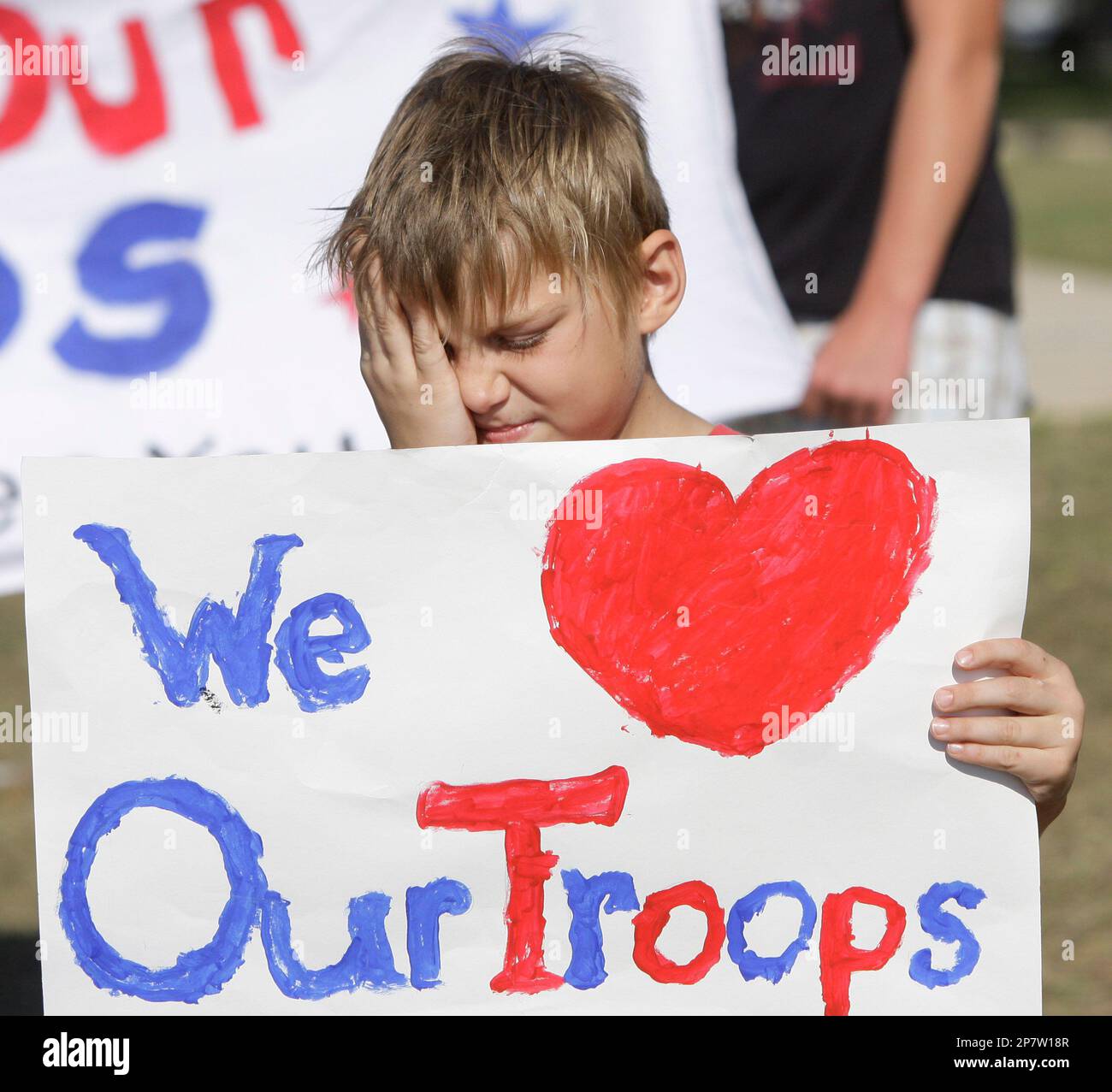 Jeremiah Thomas, of Waco, Texas, rubs his face while holding a sign ...