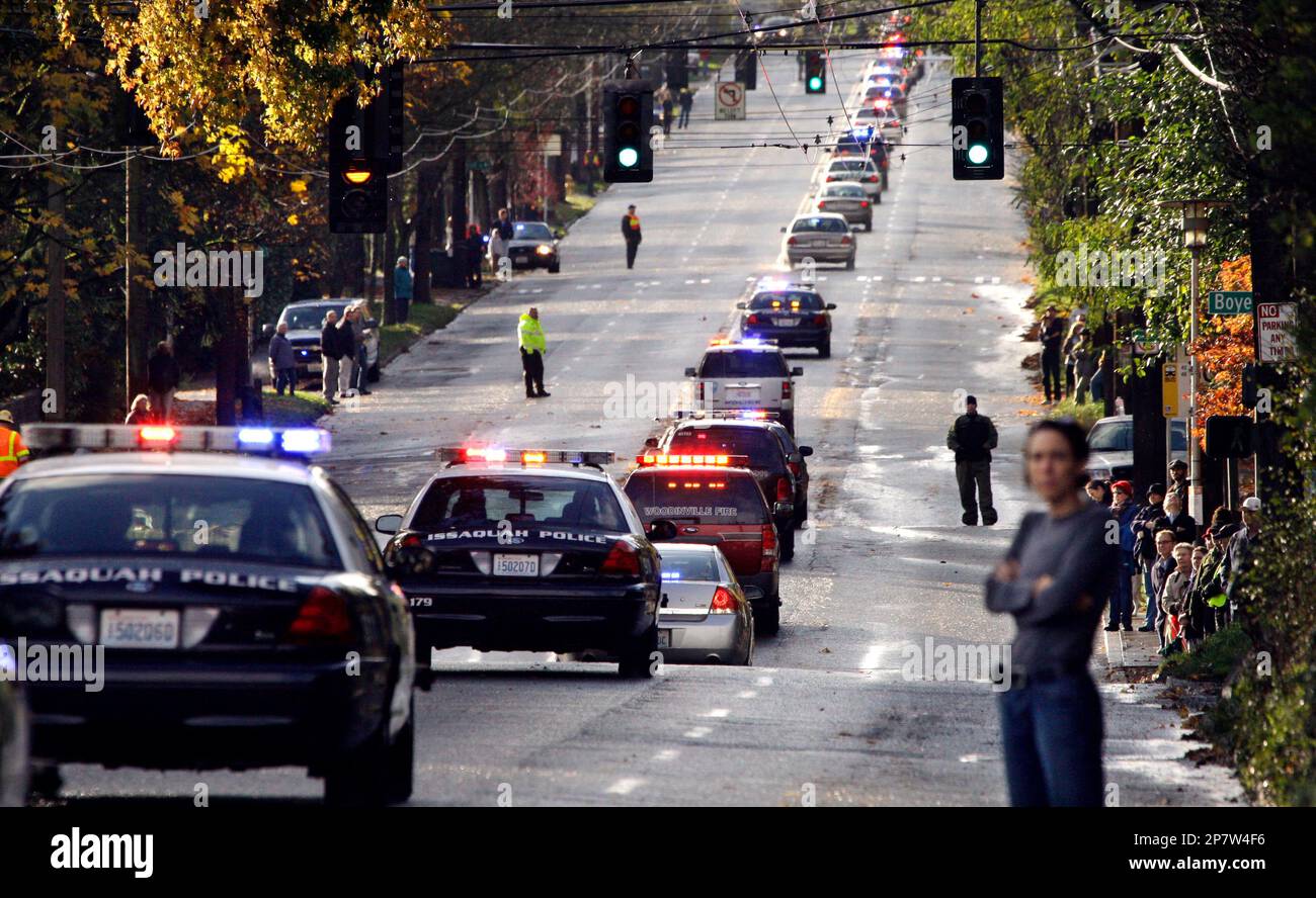 Police and neighbors stand and watch during a procession to the funeral ...