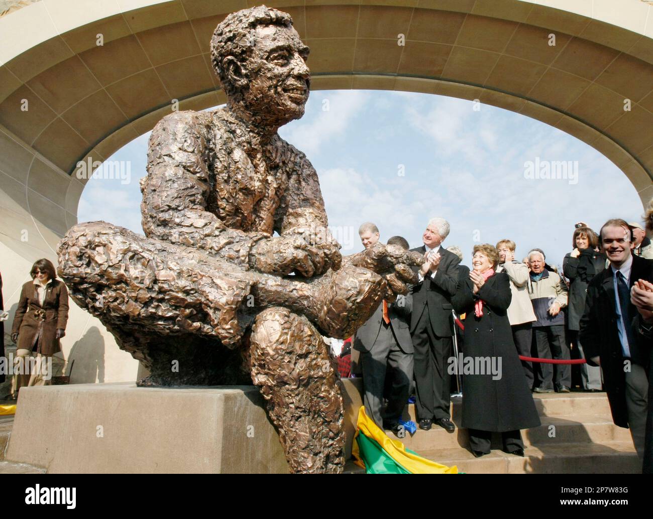 People attending the dedication applaud the unveiling of the statue of ...