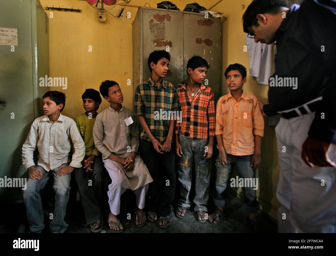 A government official, right, interrogates child laborers at a police ...
