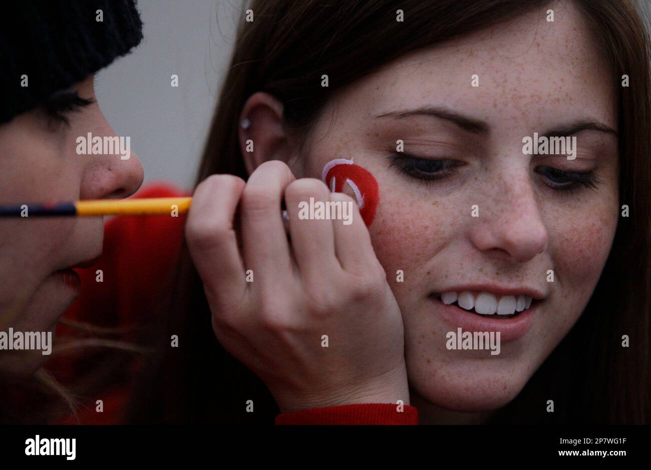 Jess Conda, left, from Elkins Park, Penn., paints a "P" on Kim Crooks ...