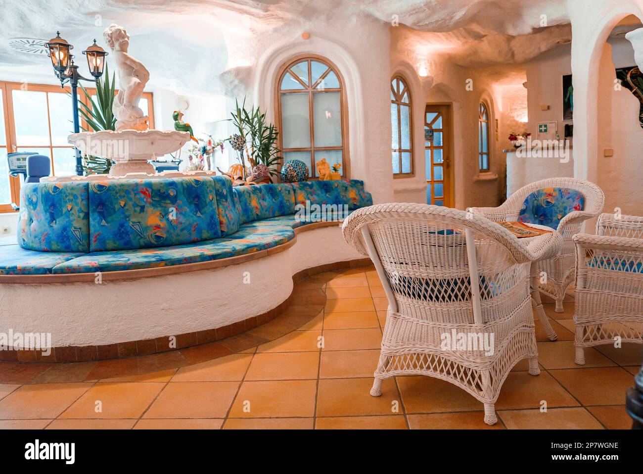 Wicker chairs and tables arranged by sofa in luxury hotel Stock Photo ...