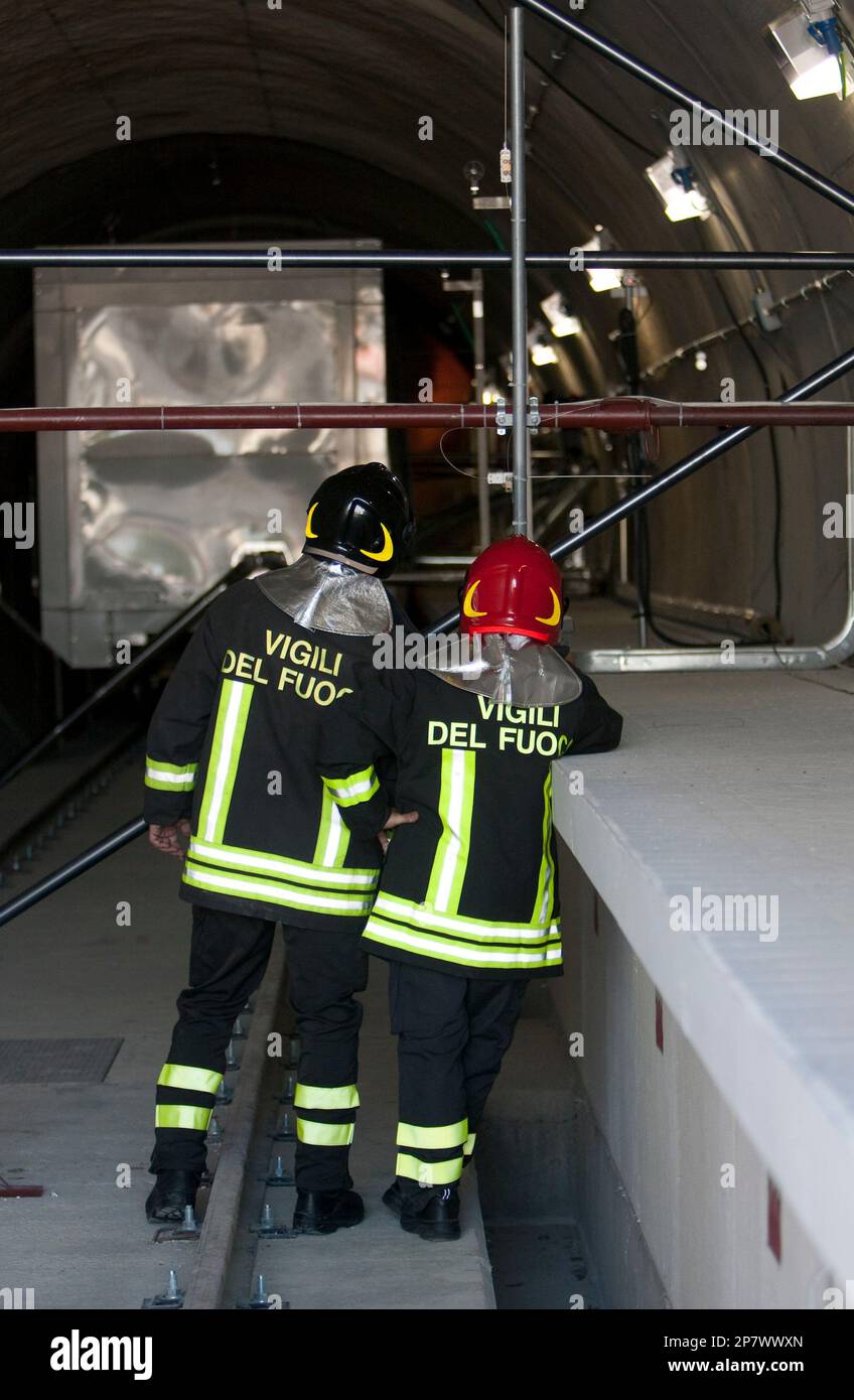 Firefighters look on as they simulate a fire on a real size model of an ...