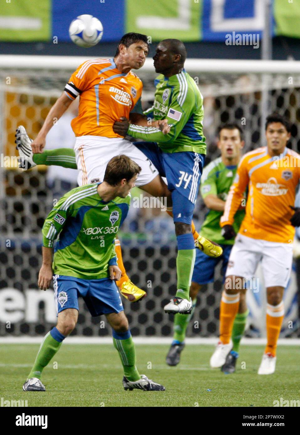 Houston Dynamo's Brian Ching, left, goes up to head the ball as Seattle ...