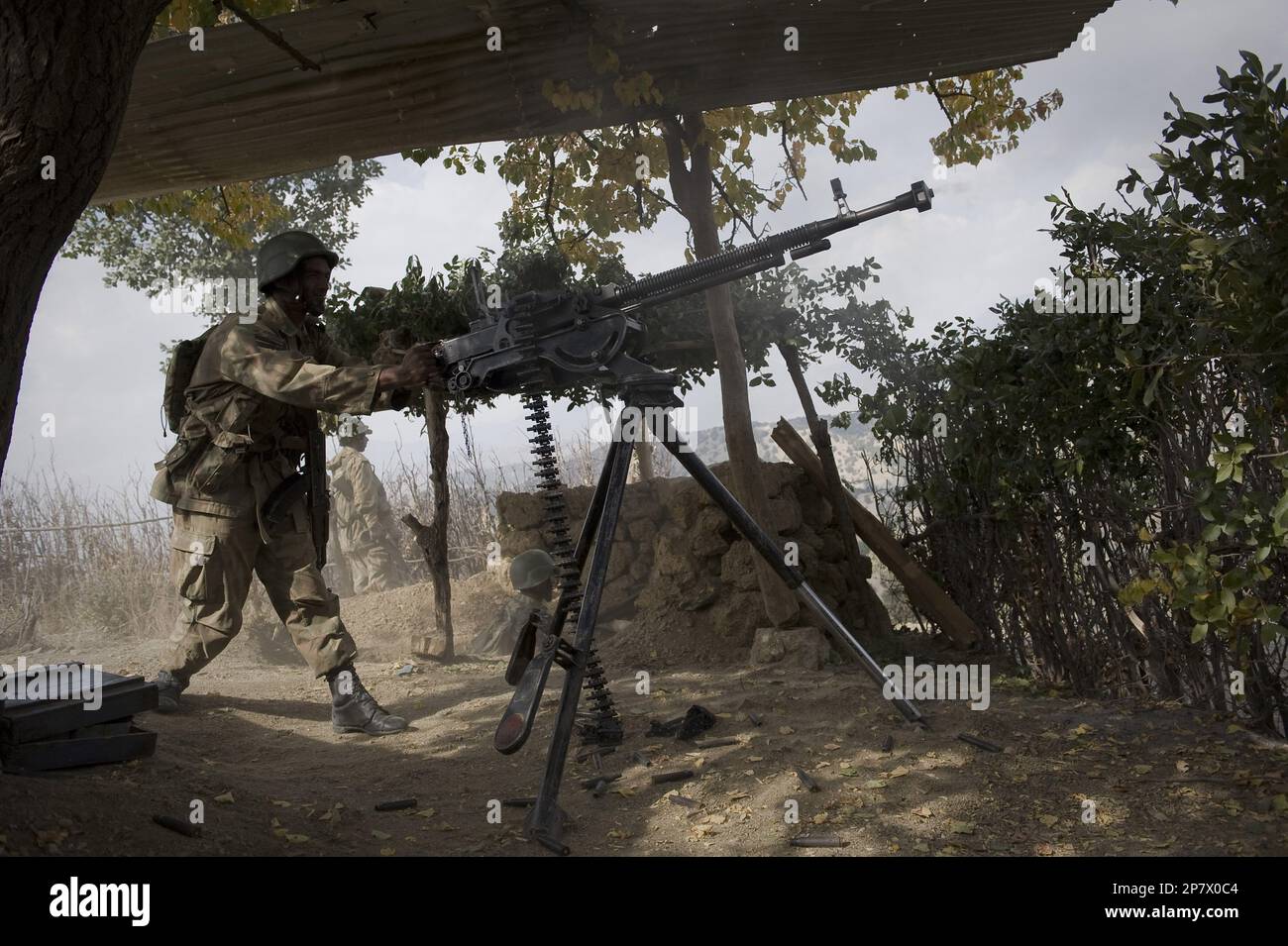 A Pakistani soldier fires a heavy machine gun on Taliban positions at ...