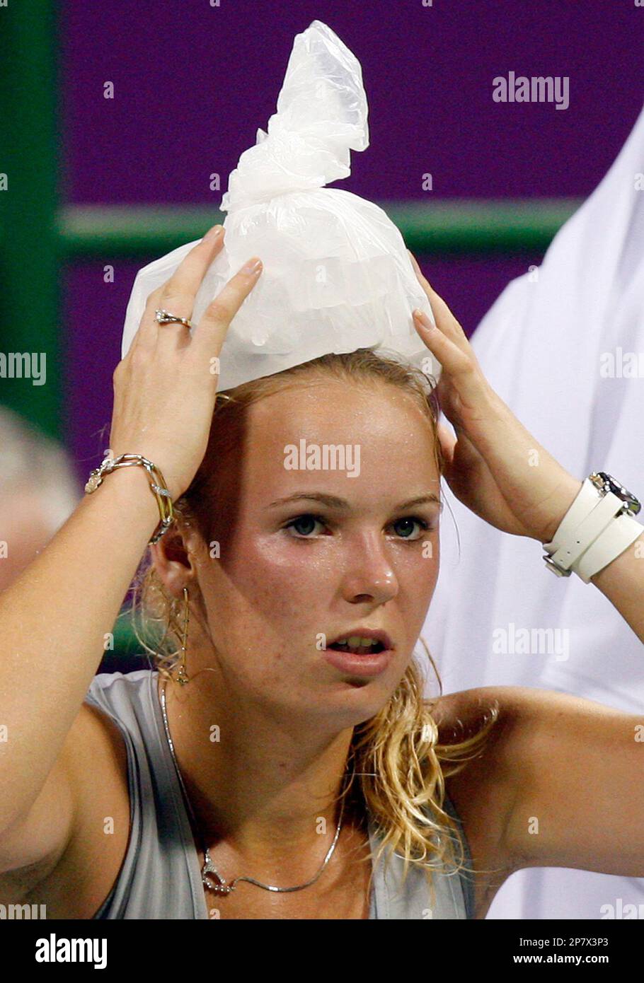 Caroline Wozniacki of Denmark cools down with ice during her singles ...