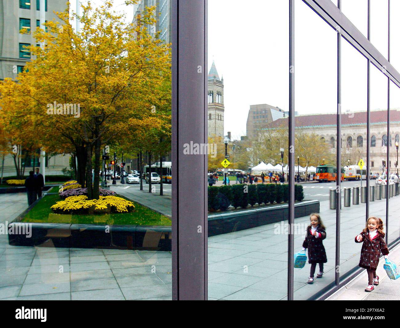A child walks alongside the John Hancock Tower in Boston Tuesday, Oct ...