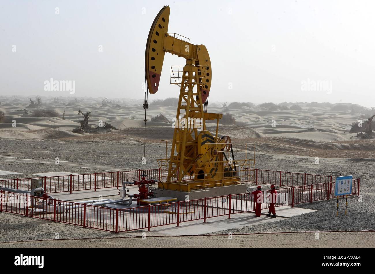Workers work at an oil well at the PetroChina's Hade Oilfield in the ...