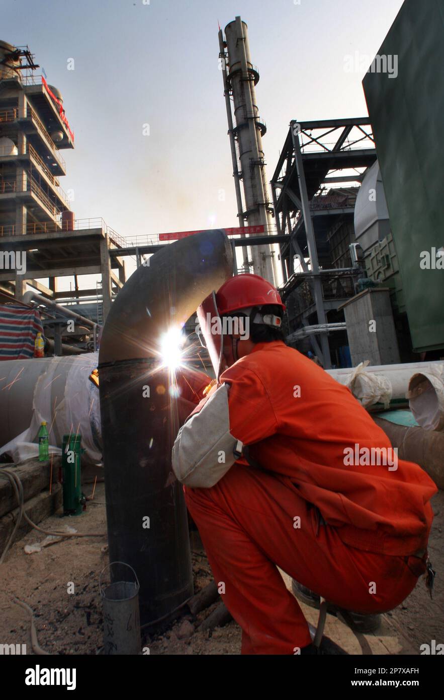 A worker welds a pipeline at the fertilizer plant of PetroChina Tarim ...