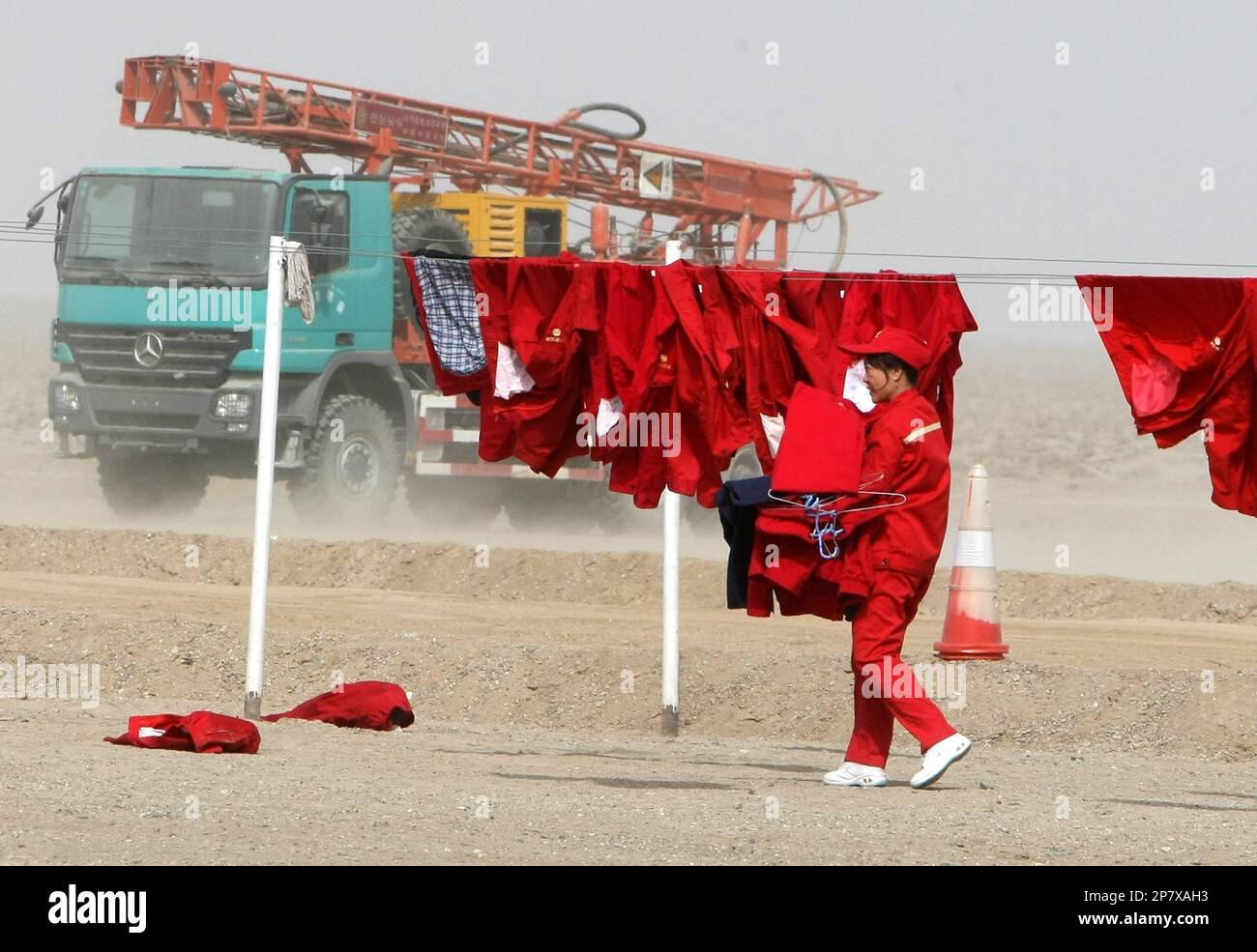 A worker of PetroChina Tarim Oilfield takes down clothes from the ...