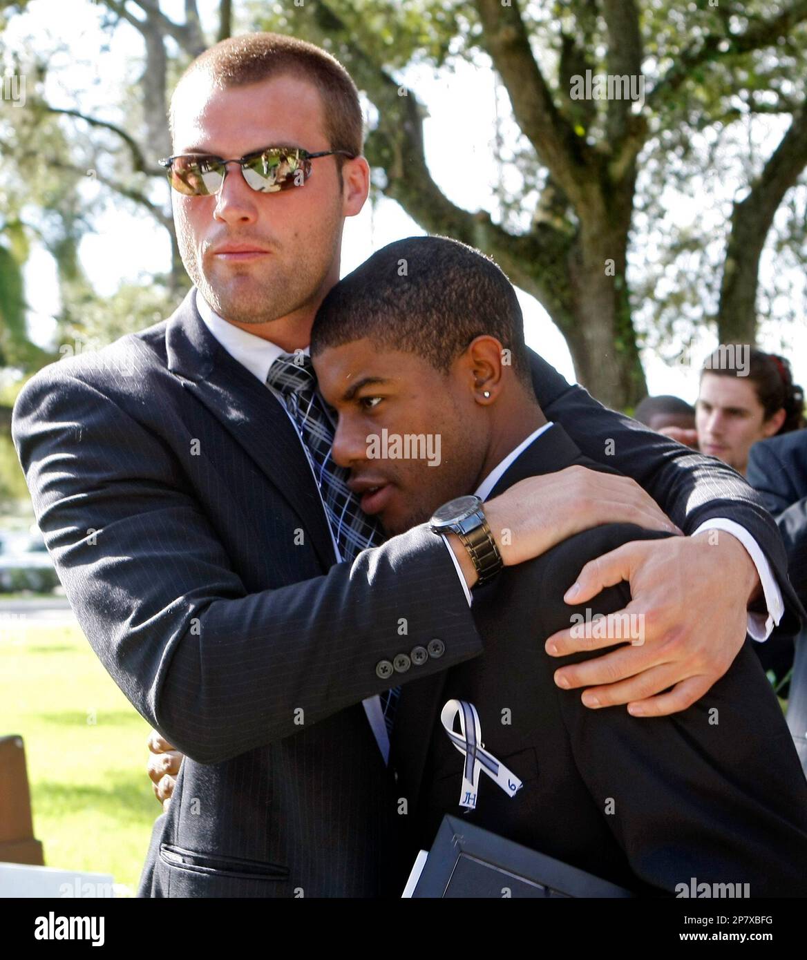 Former University of Connecticut quarterback Tyler Lorenzen, left, hugs ...
