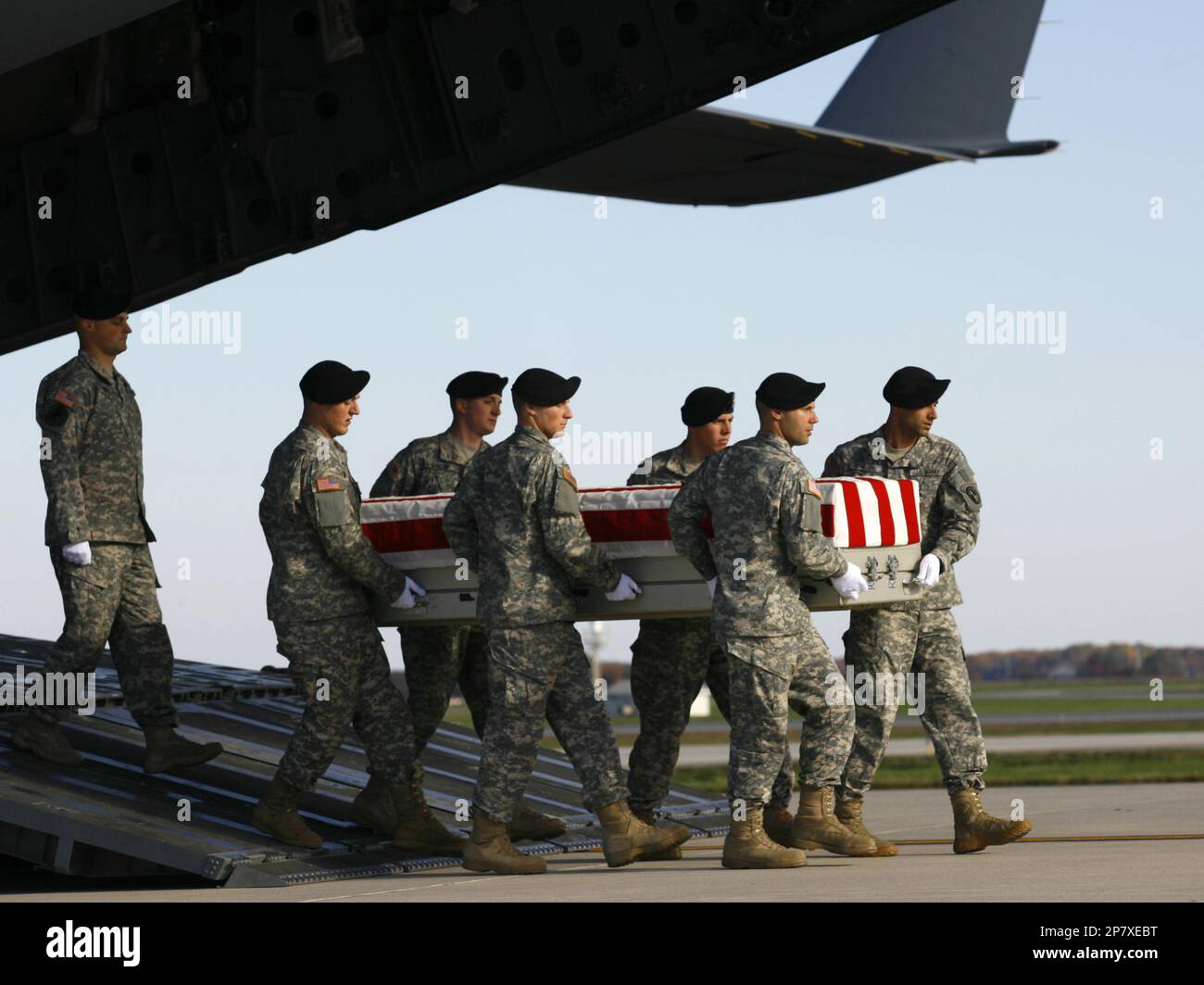 An Army carry team carries the transfer case containing the remains of ...