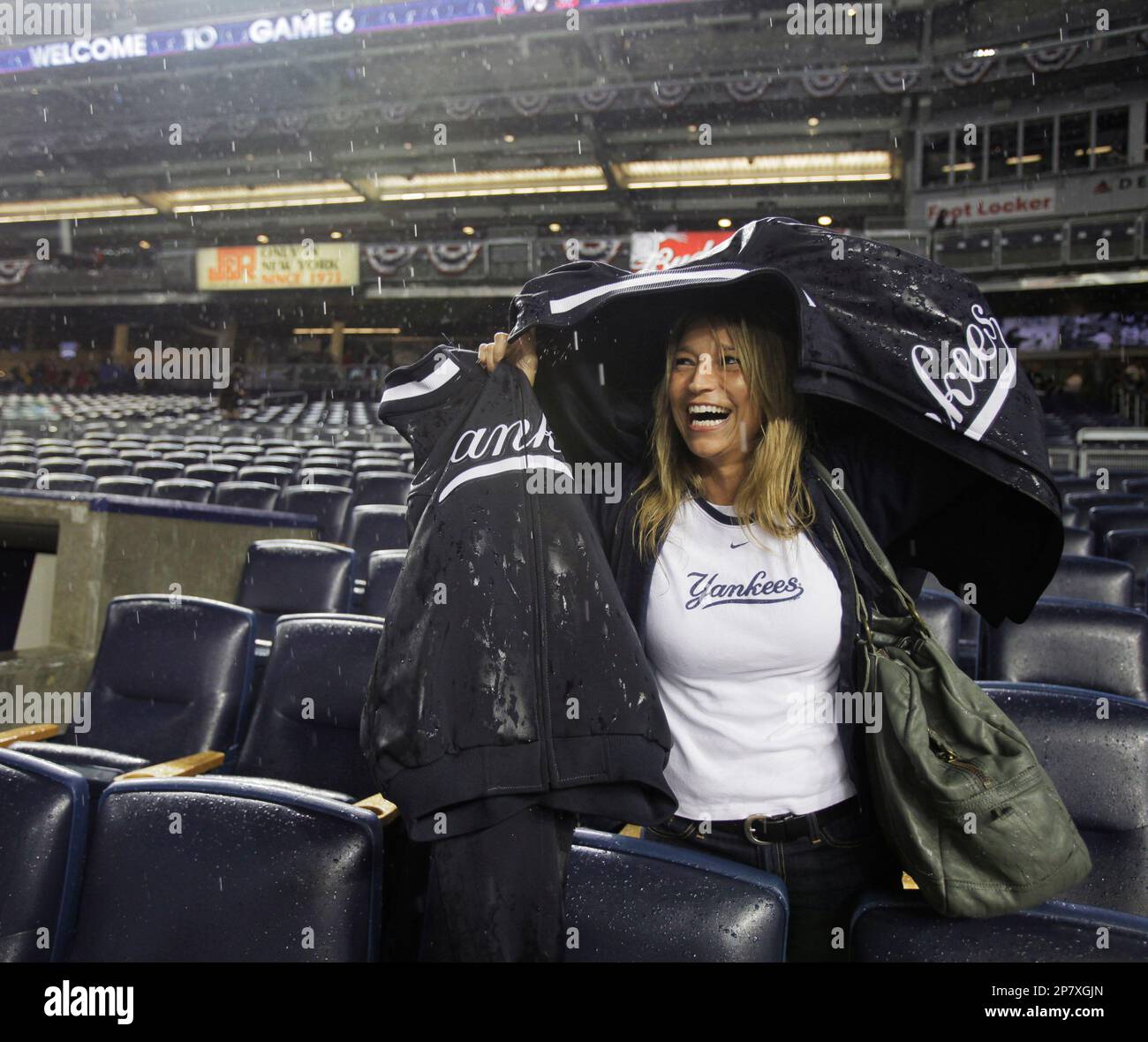 Kathy Miranda, from Norwalk, Conn., protects herself from the rain ...