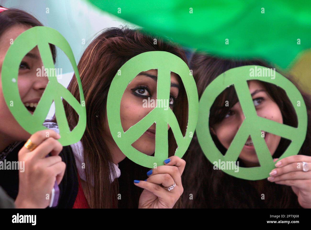 Pakistani Women Look Through Peace Signs During A Demonstration Against