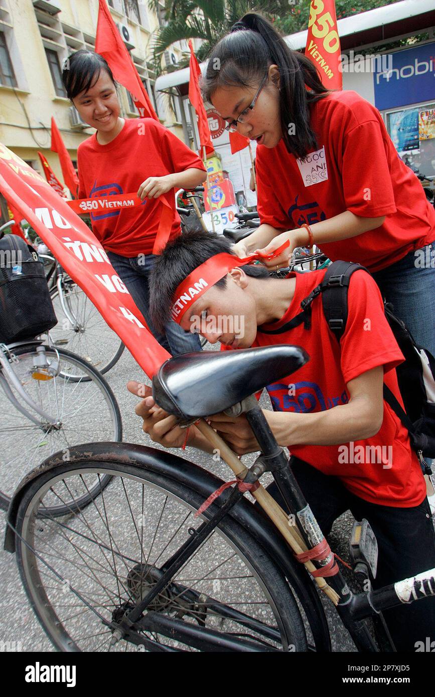 Vietnamese student Nguyen Vu Anh, center, places a banner on his bike as other students Pham ...