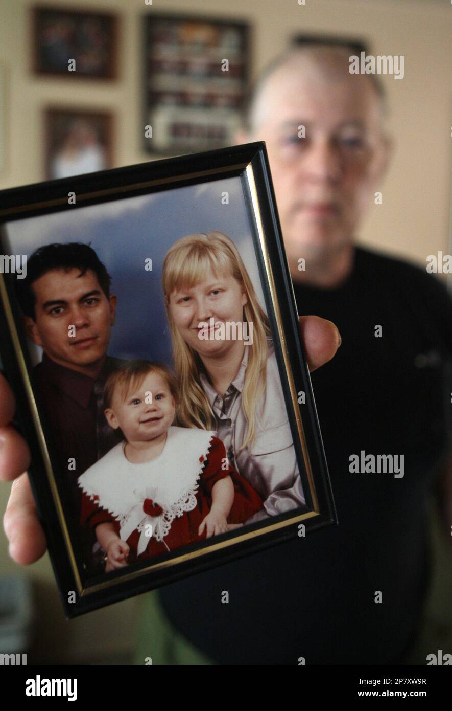 Marion Lewis holds up a photo of his daughter Lori, her husband Nelson ...