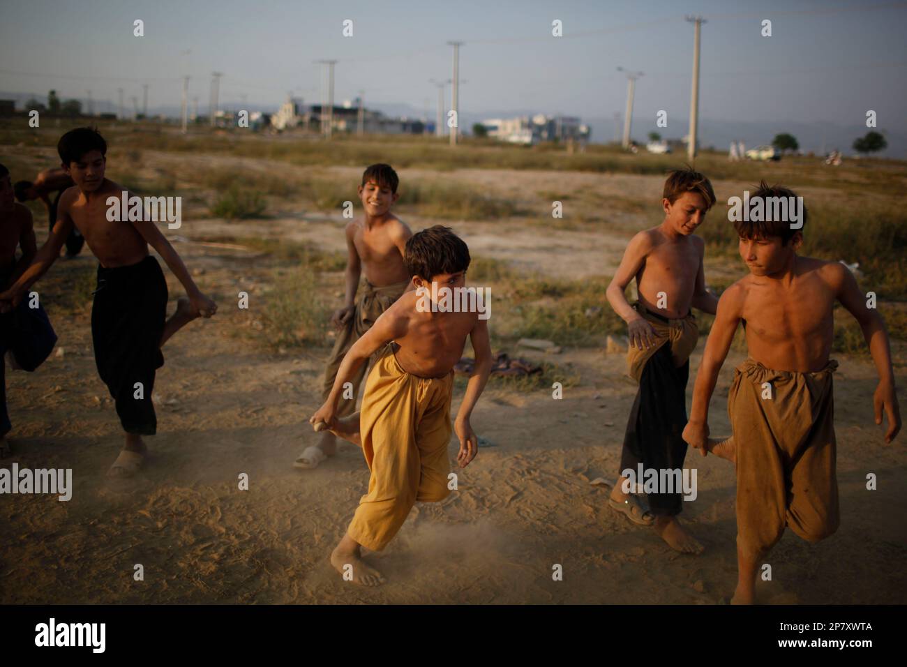 Children play a traditional game called Kabaddi, at an Afghan colony in ...