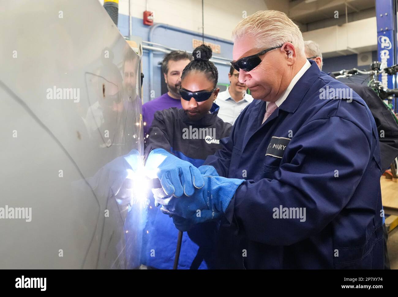 Ontario Premier Doug Ford, right, gets help from grade 11 student ...