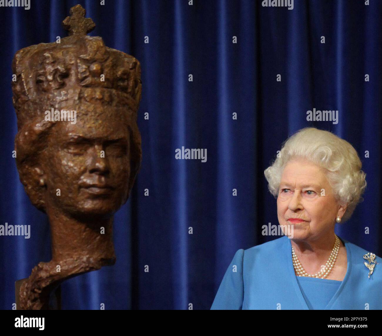 Britain's Queen Elizabeth II looks at a new a portrait bust of herself ...