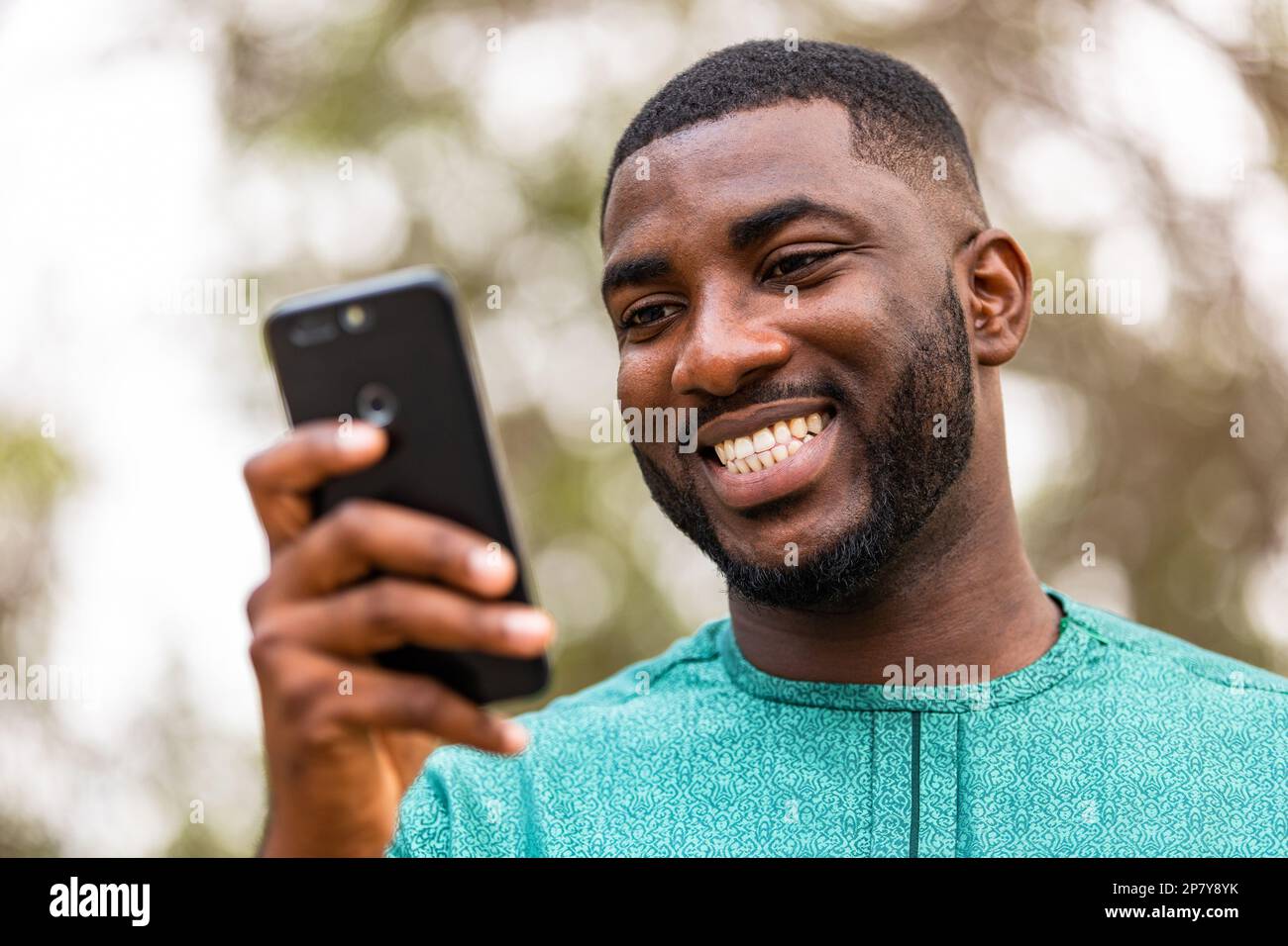 Multitasking Young African millennial using smartphone on the go ...
