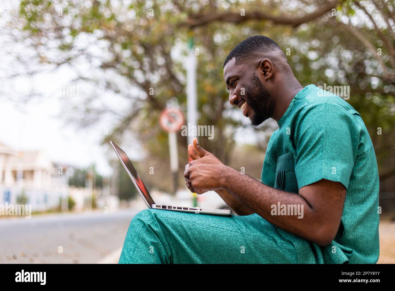 Young Black African Man with Laptop Computer doing video call outdoors ...