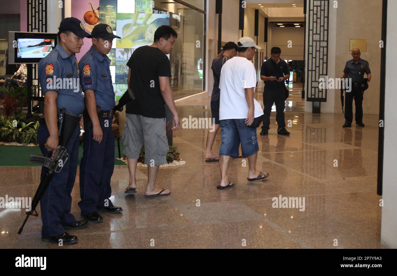 Responding police officers inspect the scene following a shootout at ...