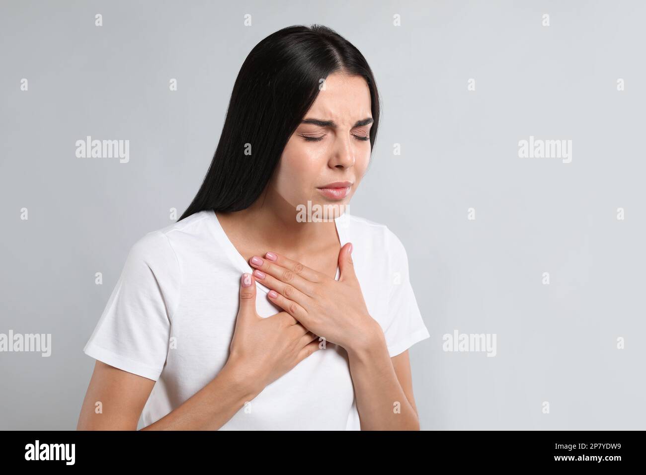 Young woman suffering from breathing problem on light background Stock ...