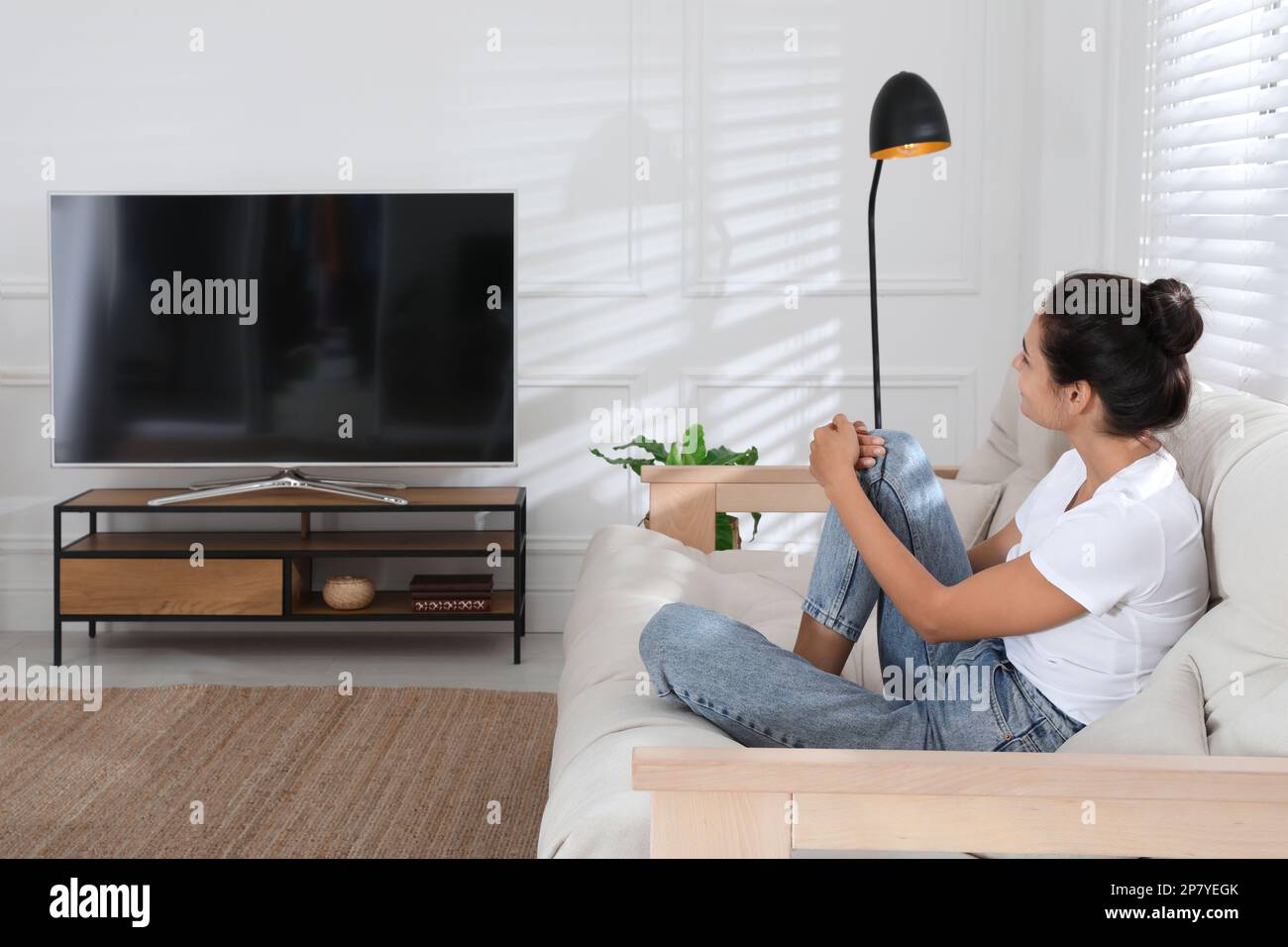 Woman watching television at home. Living room interior with TV on ...