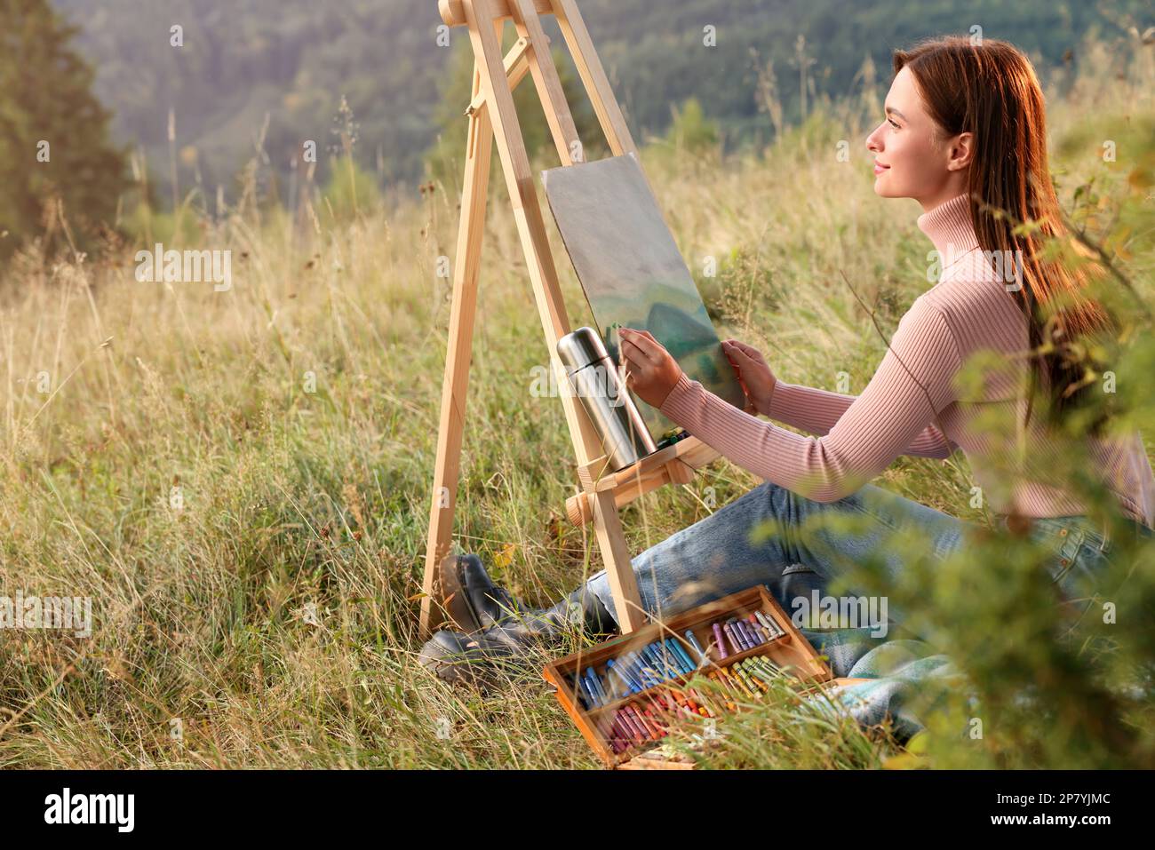 Young woman drawing landscape with soft pastels in nature. Space for ...