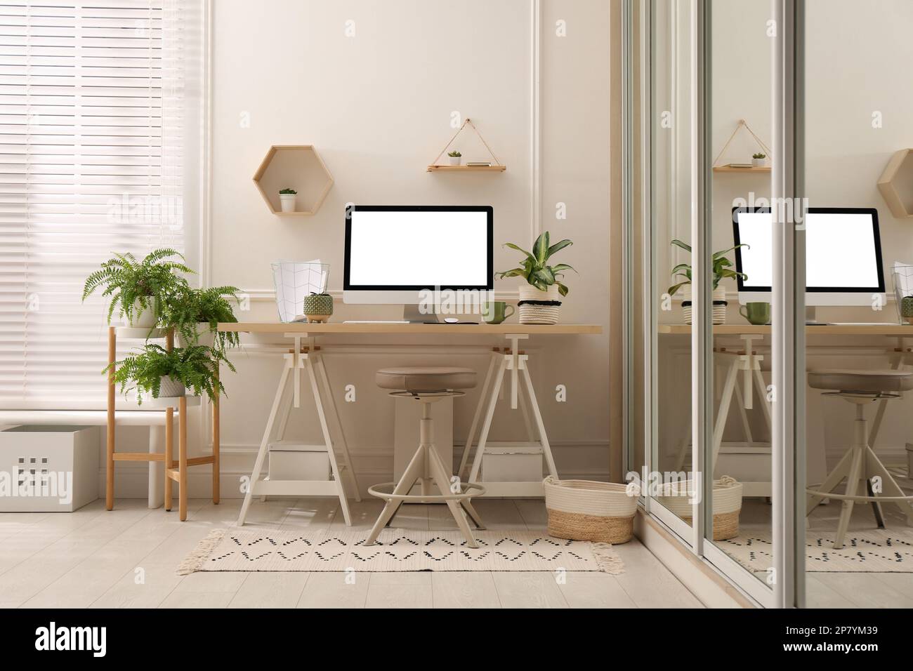 Comfortable workplace with modern computer and houseplants in room ...