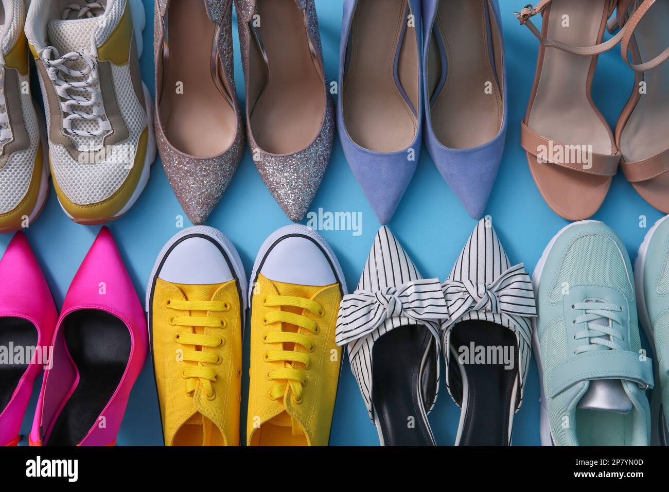Different shoes on turquoise background, flat lay. Diversity concept ...