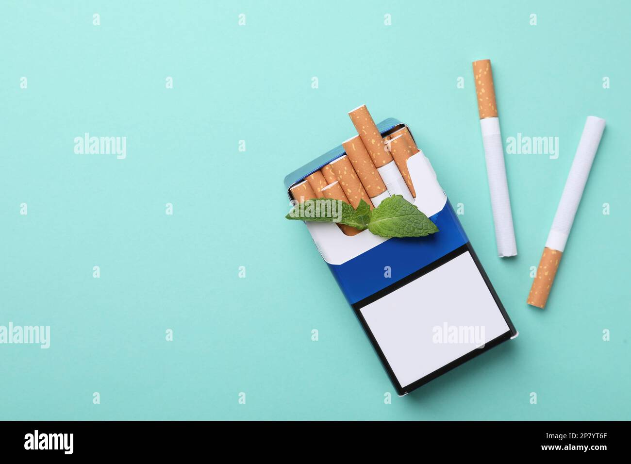 Pack of menthol cigarettes and mint on turquoise background, flat lay ...