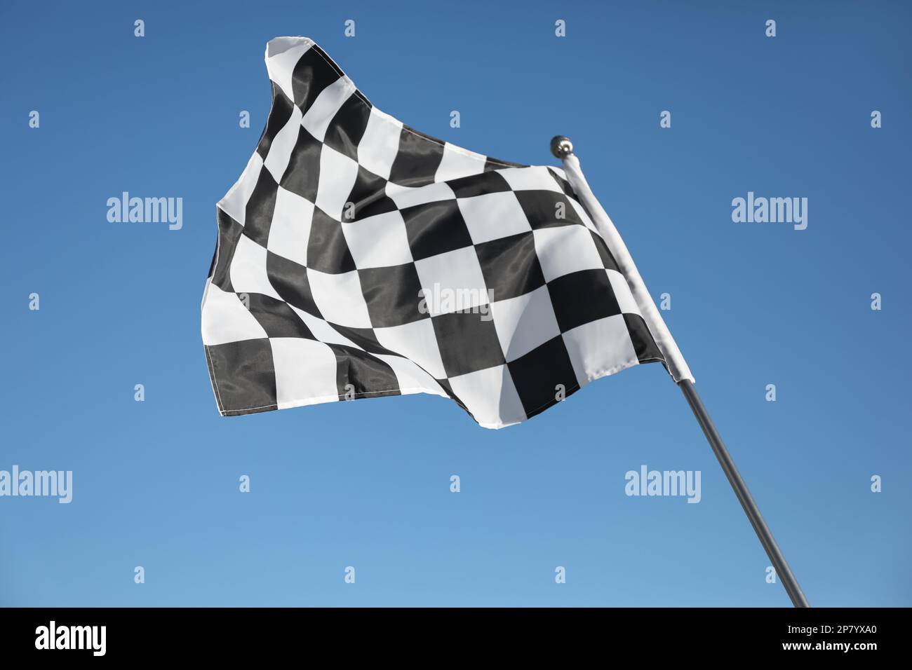 Checkered finish flag on light blue background Stock Photo - Alamy