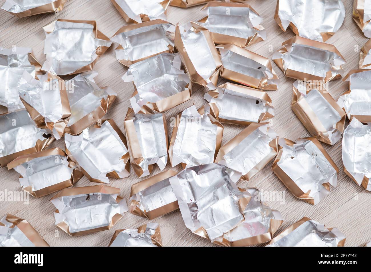 Pile of empty silver-gold candy wrappers. Top view Stock Photo - Alamy