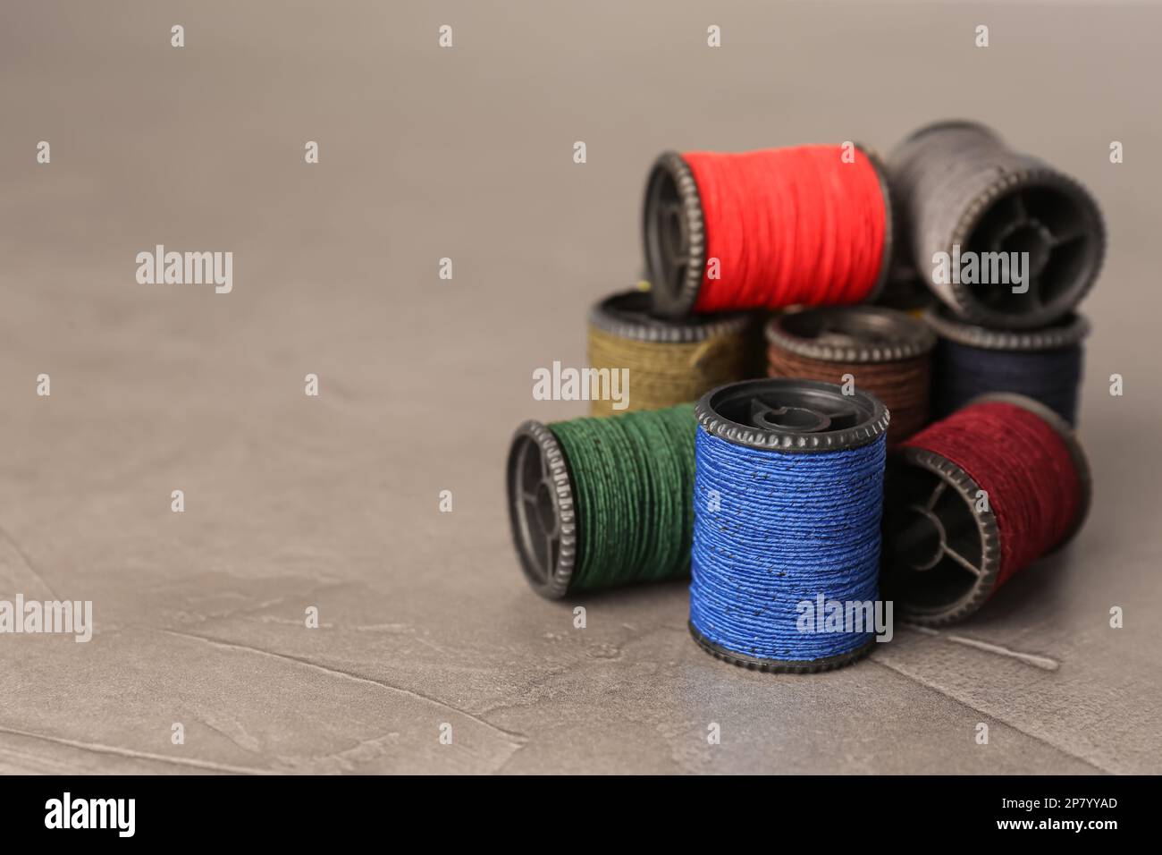 Set of color sewing threads on grey table, space for text Stock Photo ...