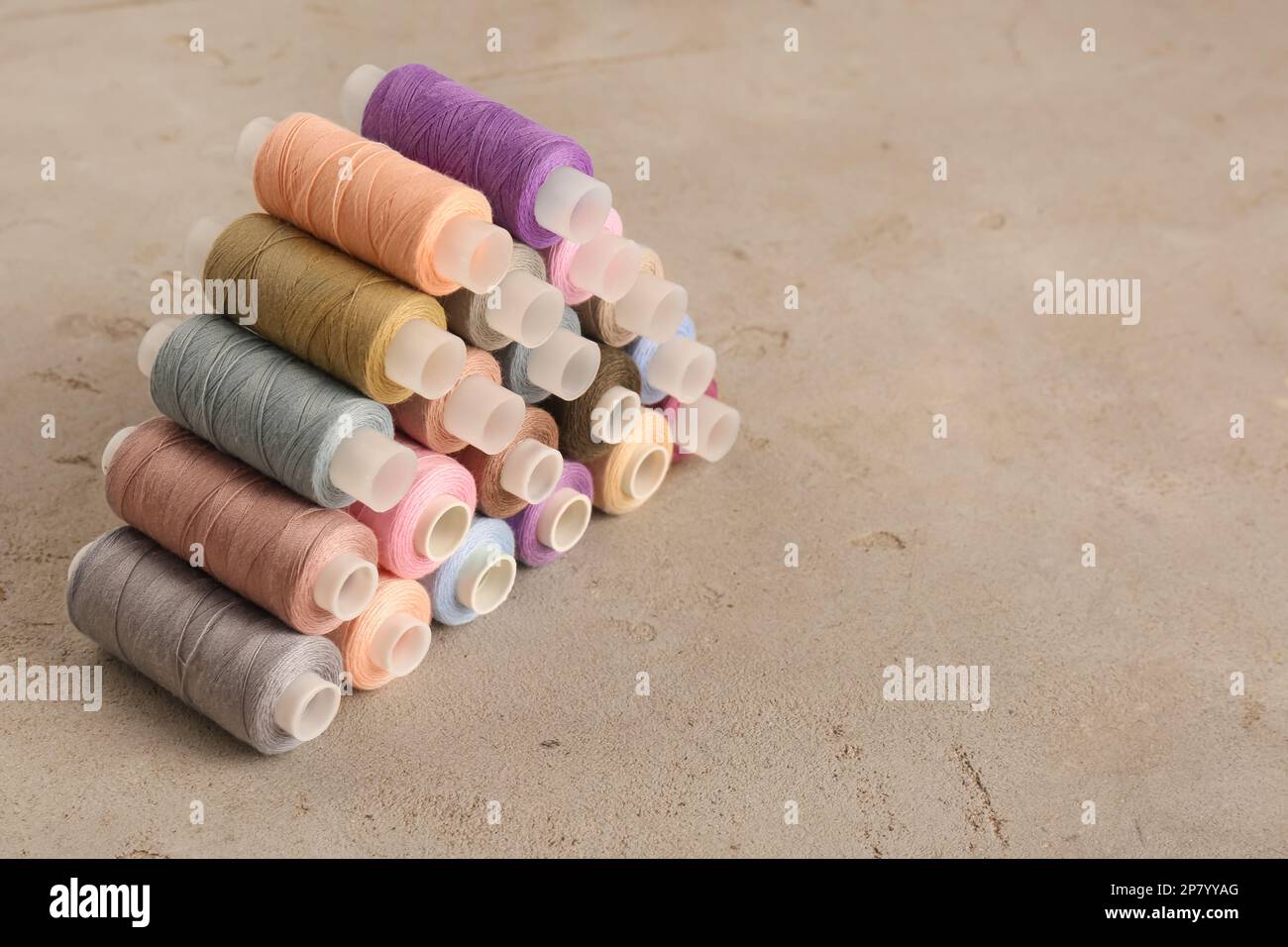 Set of color sewing threads on grey table, space for text Stock Photo ...