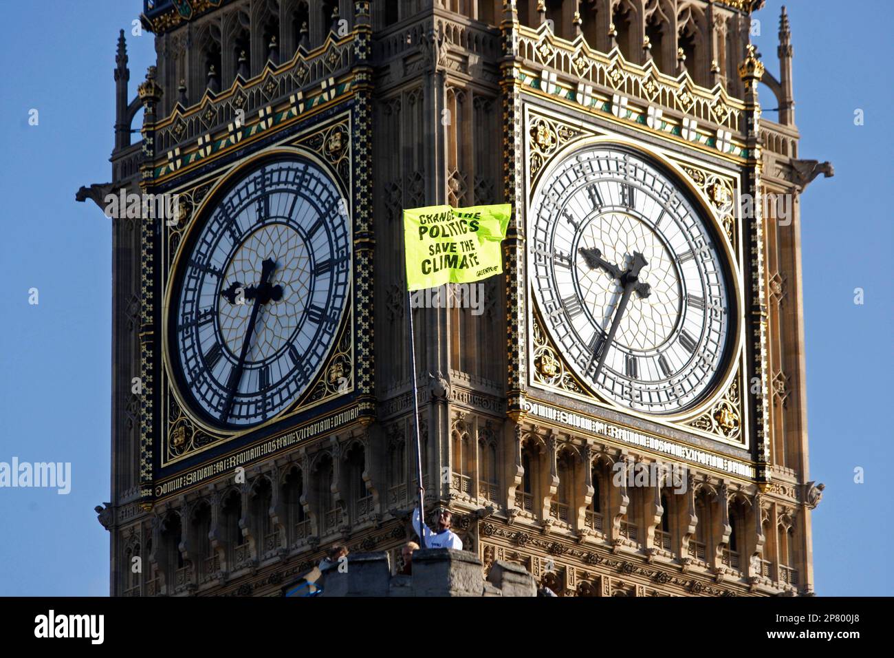A climate activist waves a banner as tens of activist continue their ...