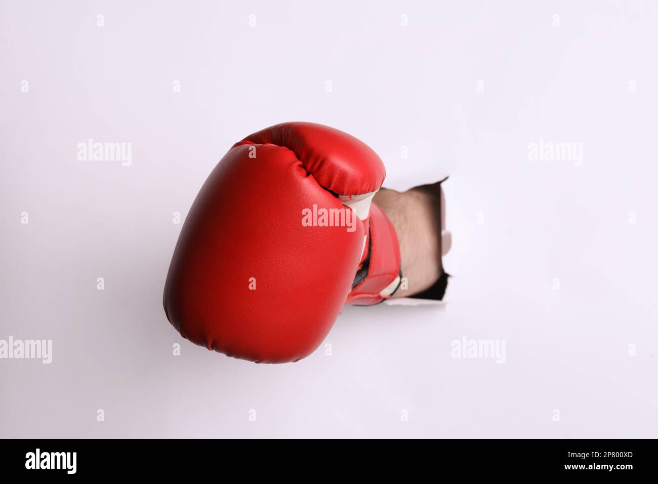 Man breaking through white paper with boxing glove, closeup Stock Photo ...