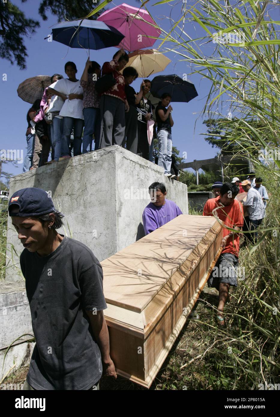 Filipino men carry a coffin during mass burial rites for landslide ...