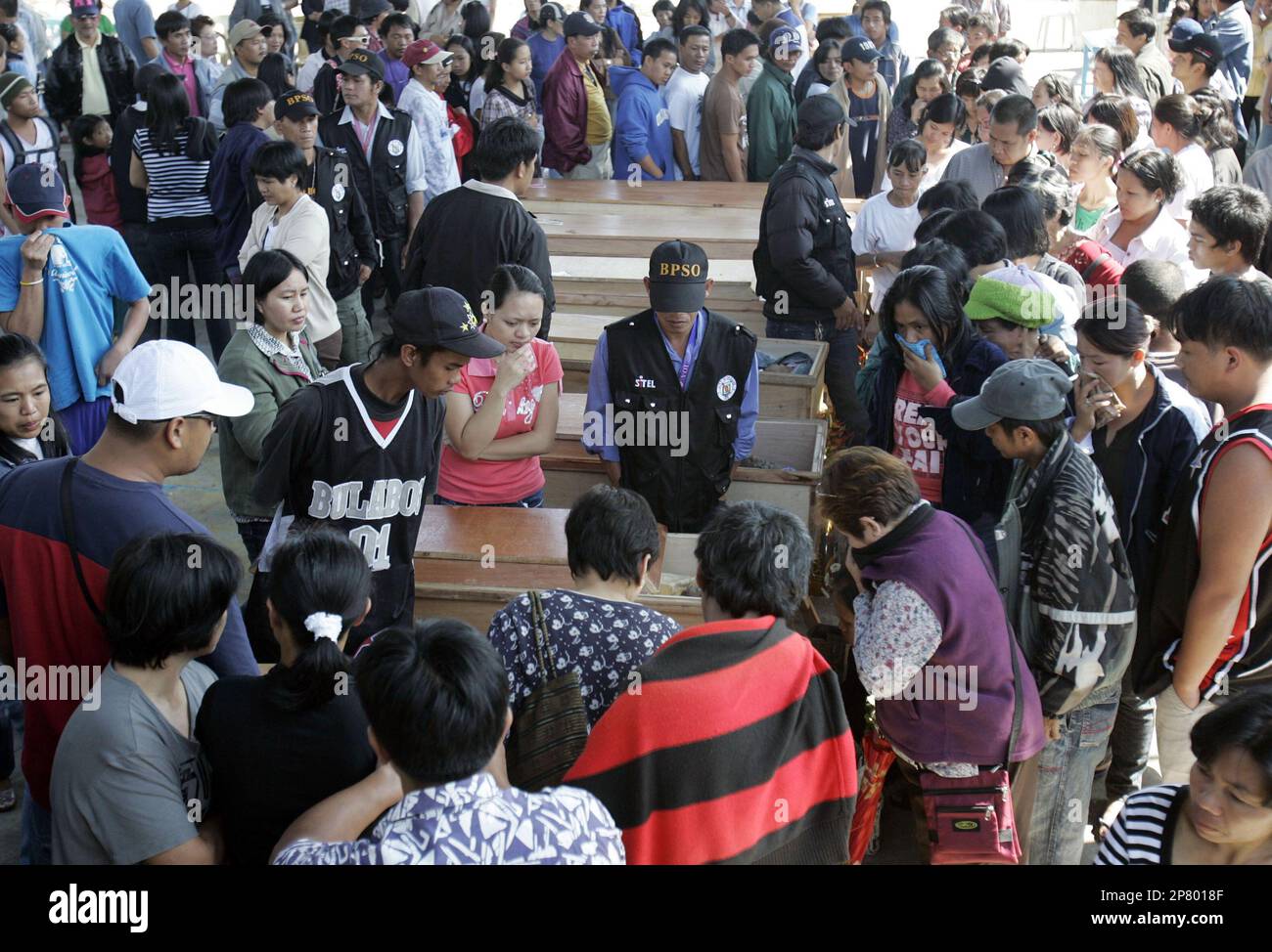 Relatives and friends view bodies of landslide victims during burial ...